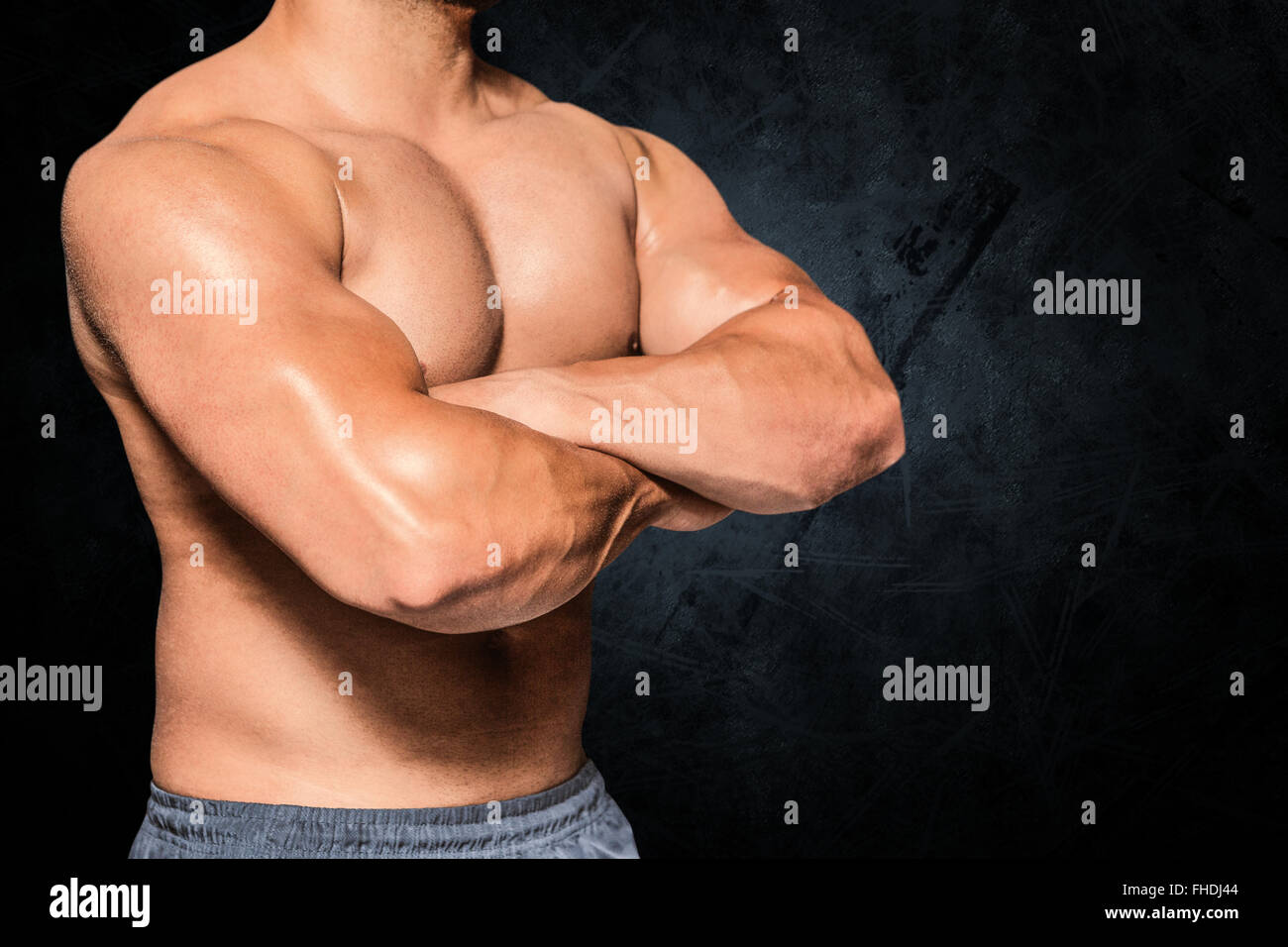 Composite image of mid section of a bodybuilder man with arms crossed ...