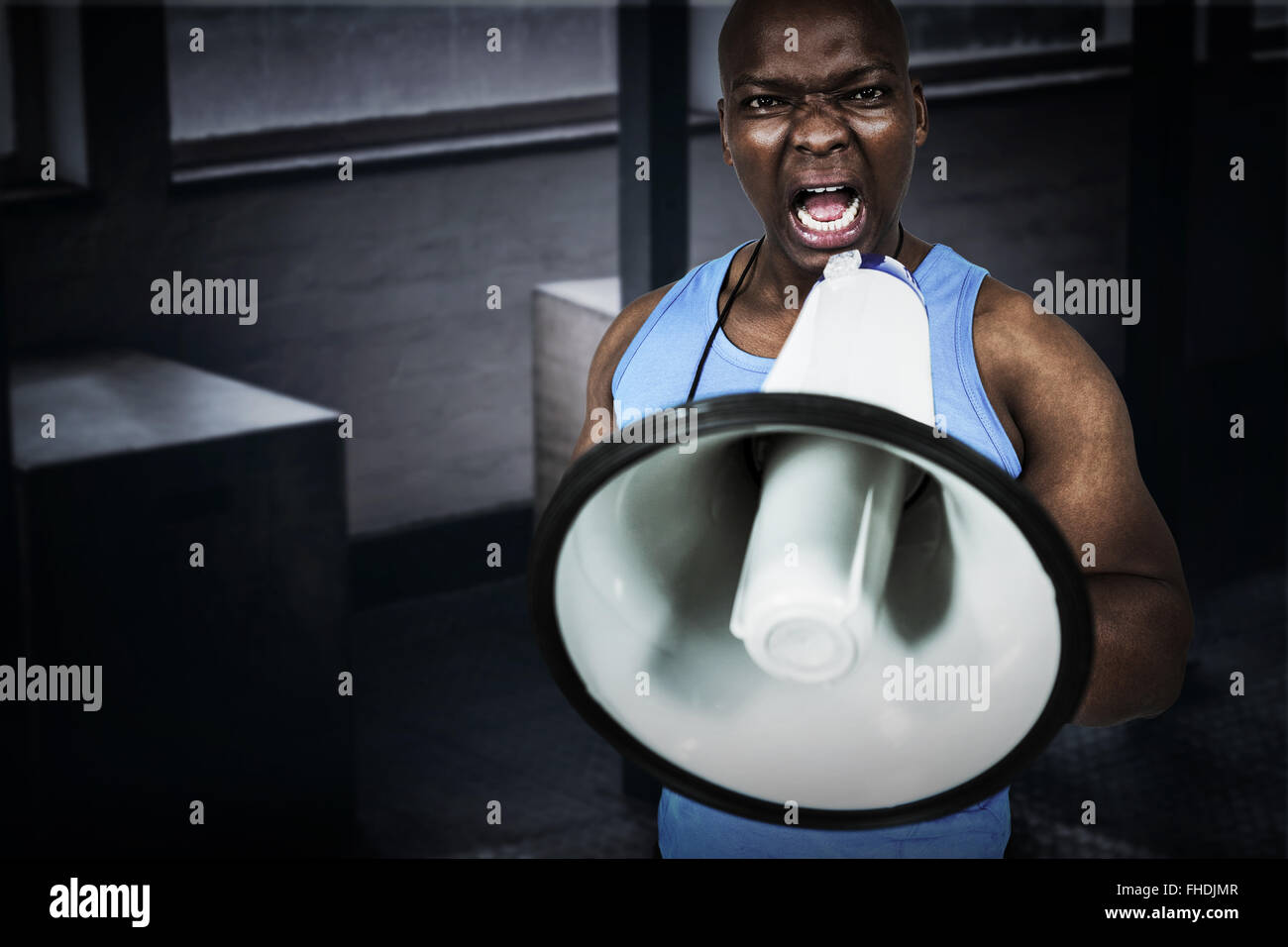 Composite image of fit trainer shouting through megaphone Stock Photo ...