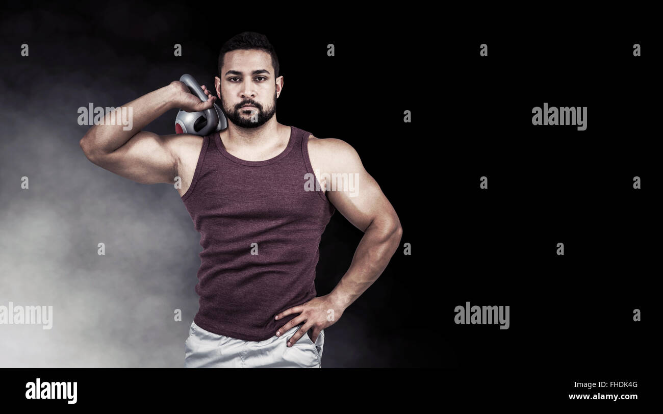 Composite image of muscular serious man holding a kettlebell Stock ...