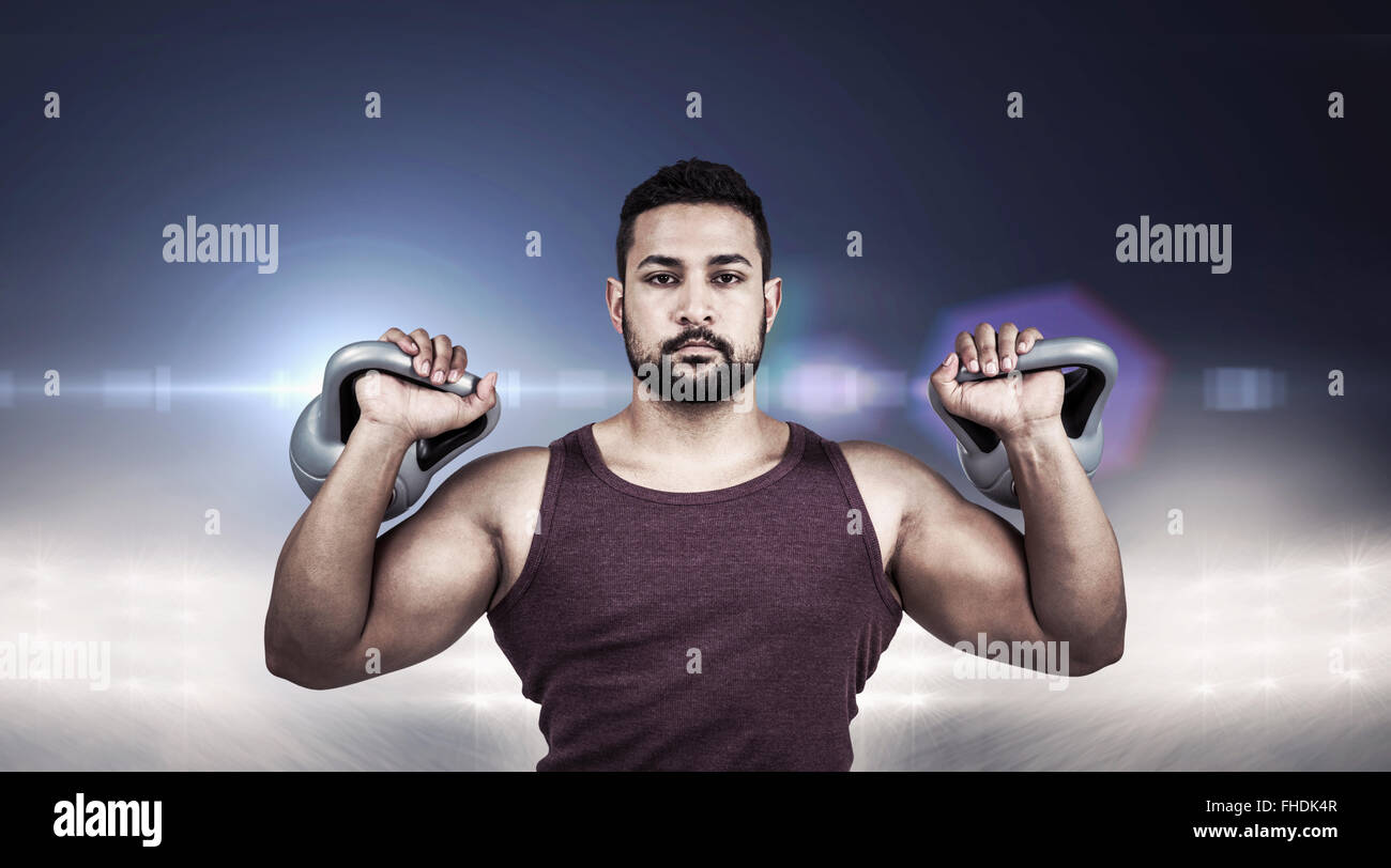 Composite image of muscular serious man lifting kettlebells Stock Photo ...