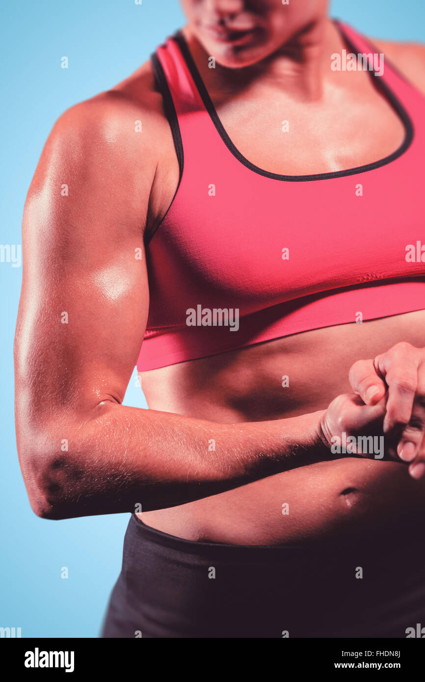 Composite image of muscular woman flexing her arm Stock Photo - Alamy