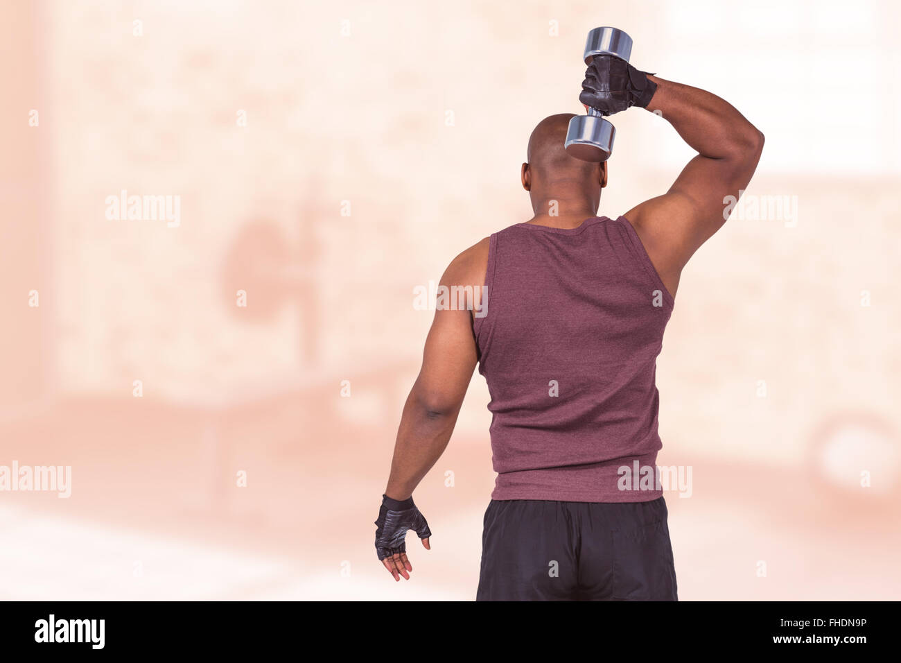Composite image of fit man exercising with dumbbell Stock Photo - Alamy