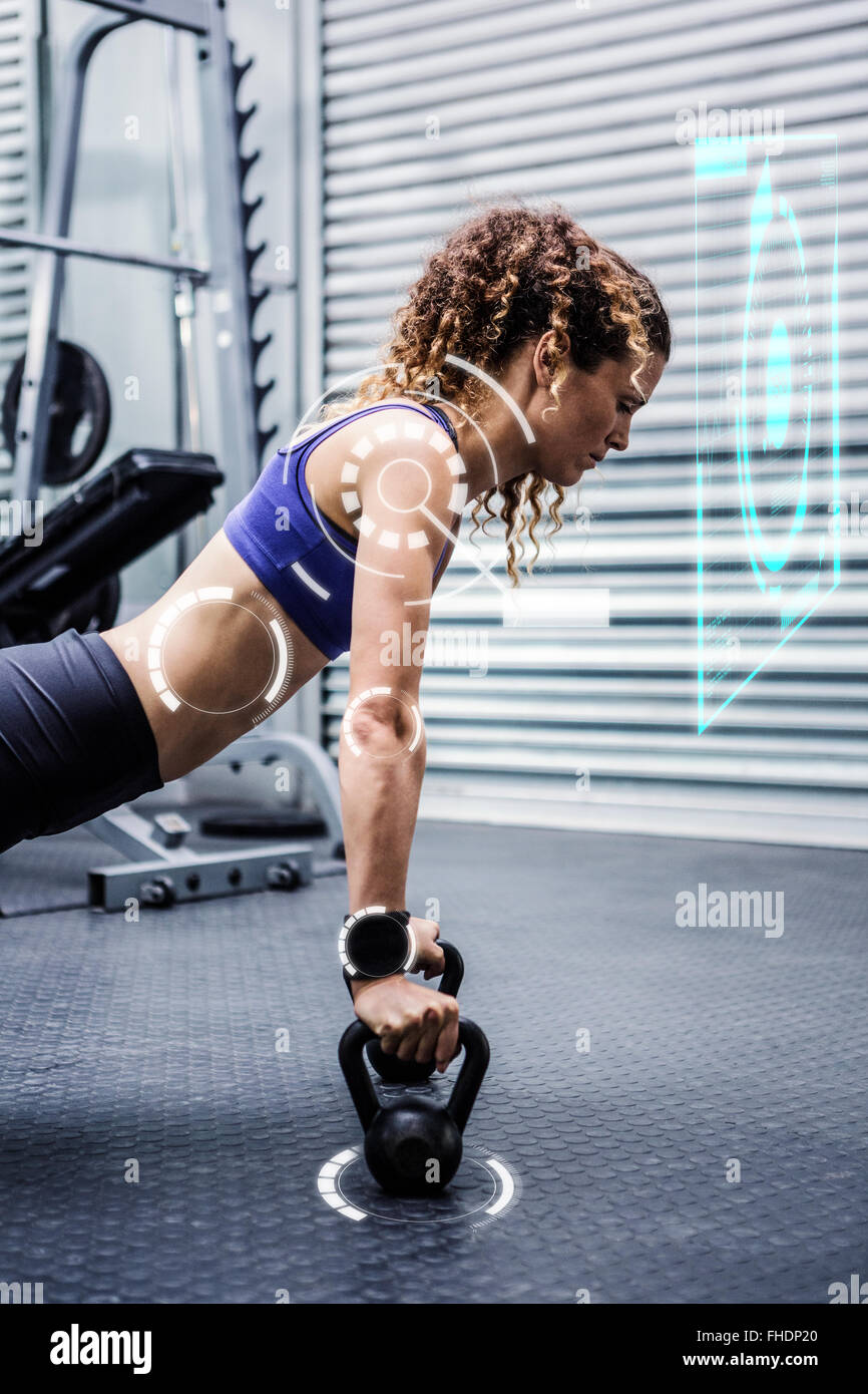 Composite image of muscular woman doing push-ups with kettlebells Stock ...