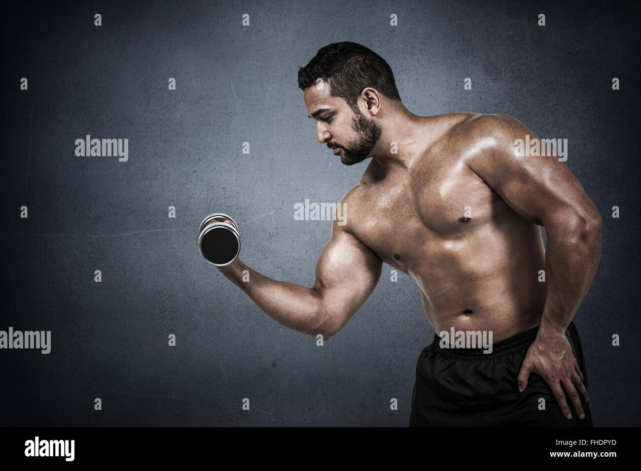 Composite image of muscular man lifting heavy dumbbell Stock Photo - Alamy