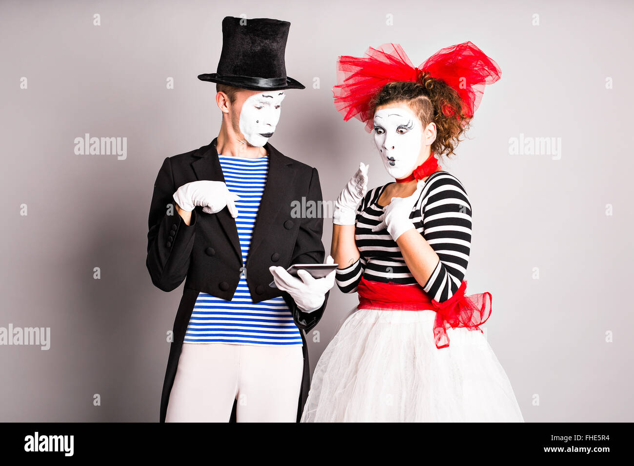 Two actors using digital tablet over white background. Horizontal shot ...