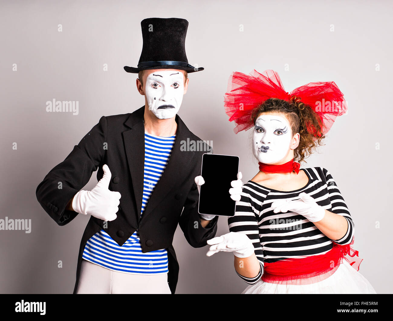 Two actors using digital tablet over white background. Horizontal shot ...