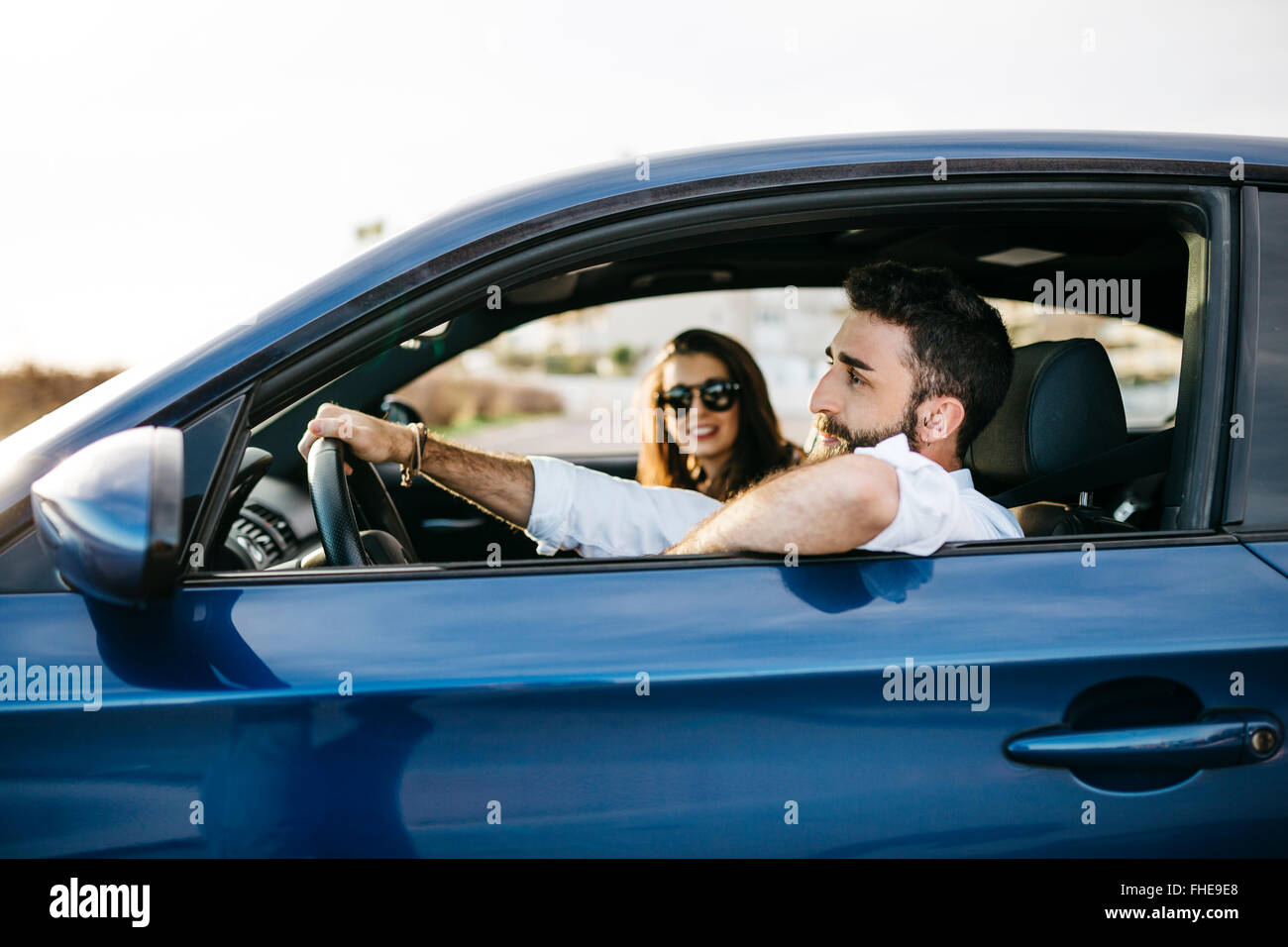 Young couple driving in a car Stock Photo - Alamy