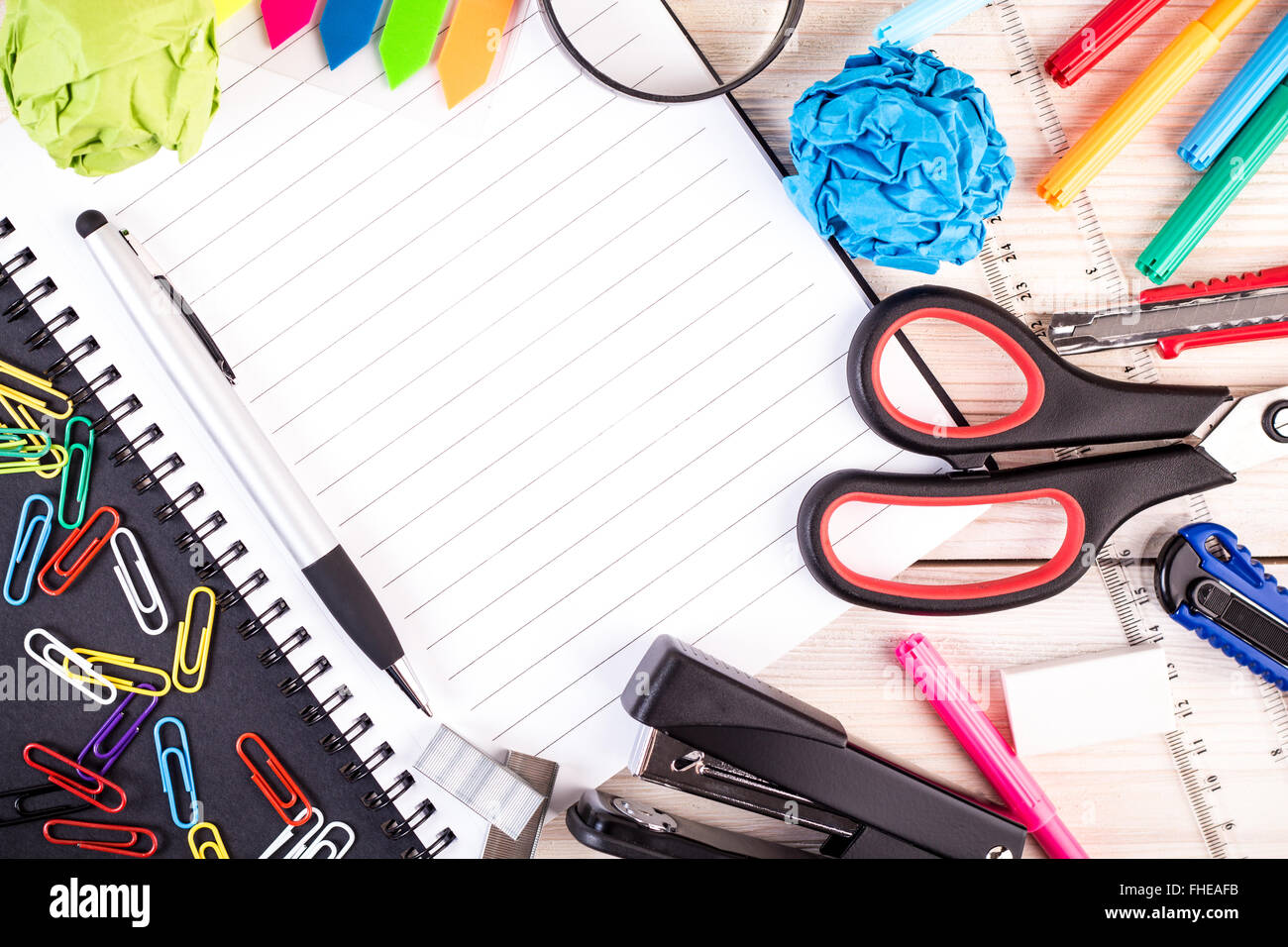 Office supplies on wooden desk with striped notepad for text Stock ...
