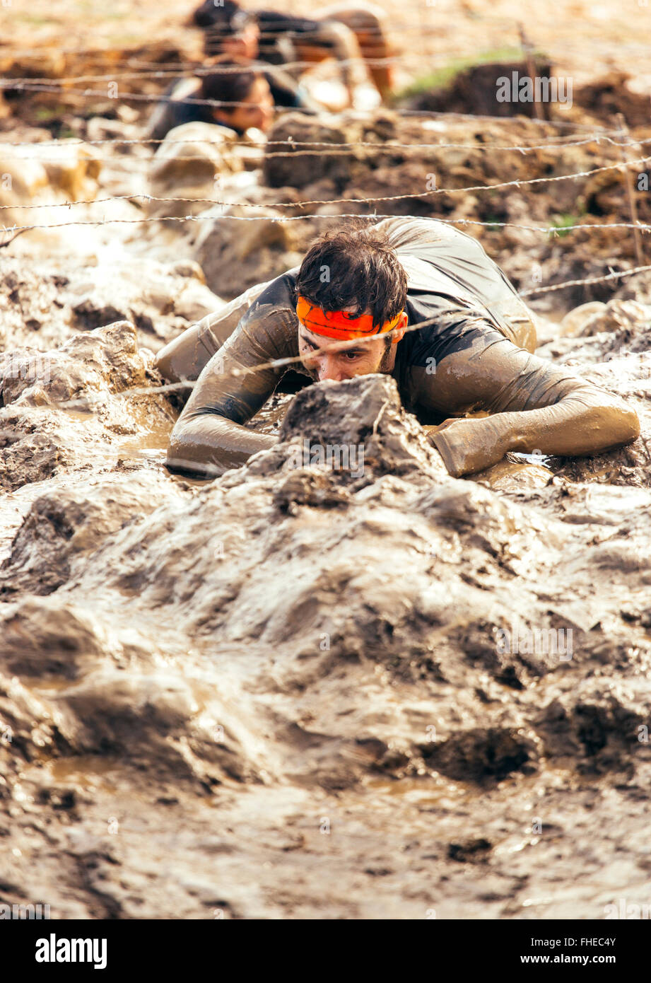 Participant in extreme obstacle race crawling under barbed wire Stock ...