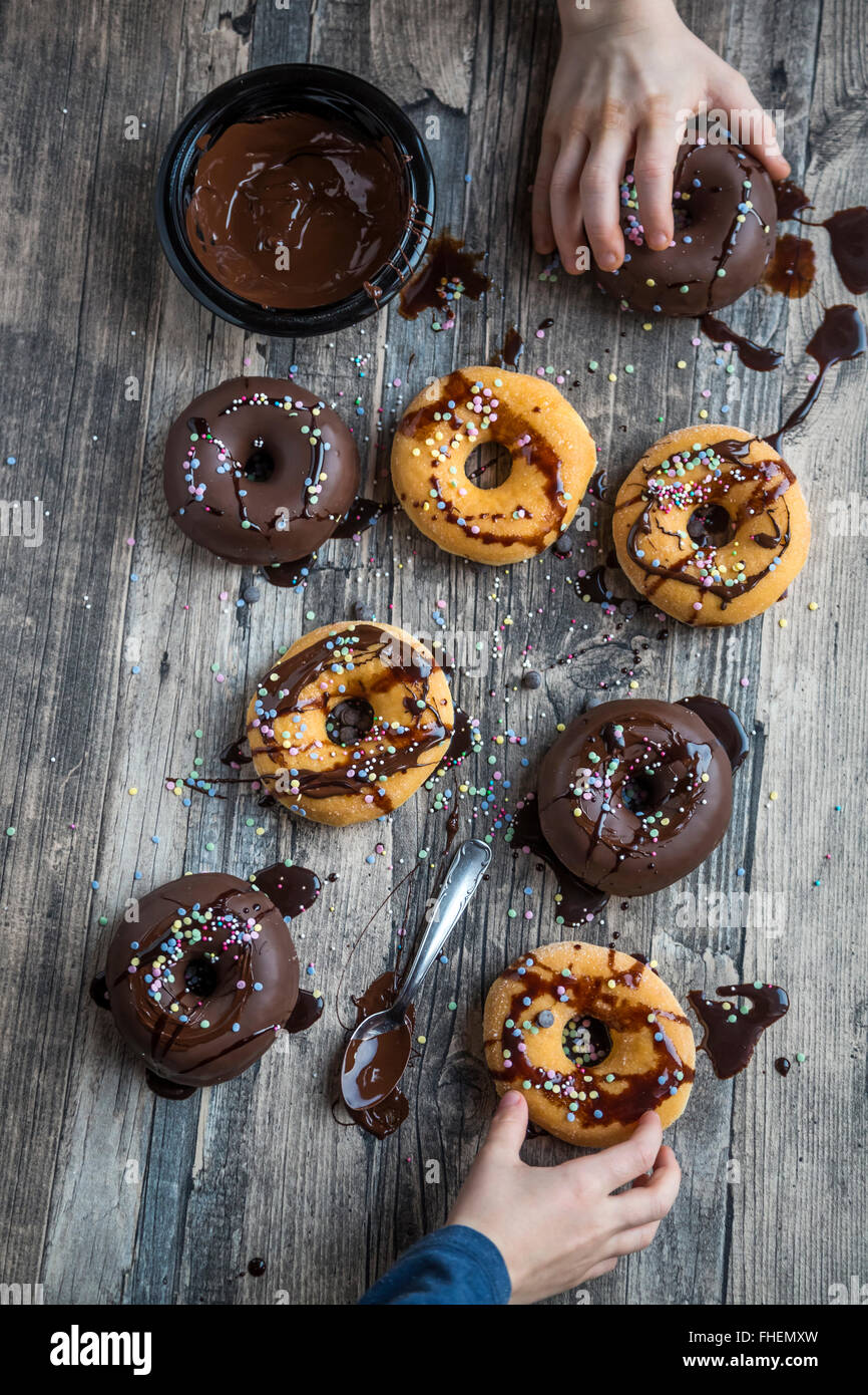 Hands of boy and girl taking doughnuts Stock Photo - Alamy