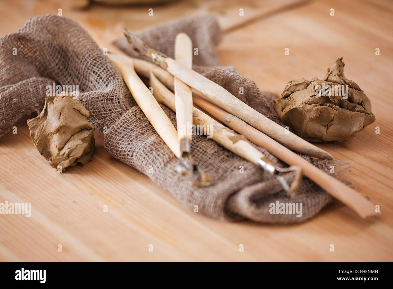 Closeup of dirty professional tools of sculptor and pieces of clay on ...
