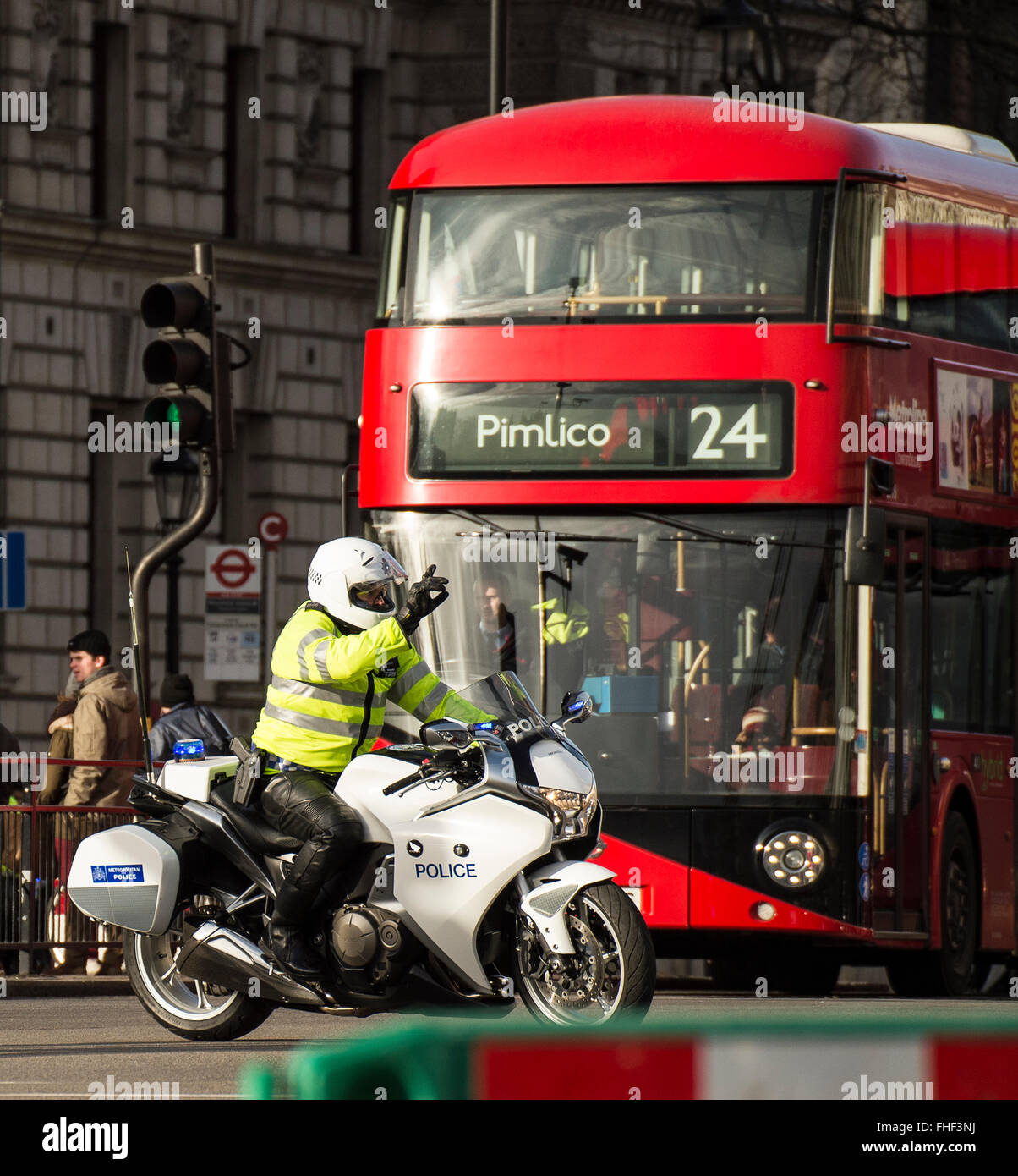 Police motorcyclist holds up traffic in Whitehall London with number 24 ...