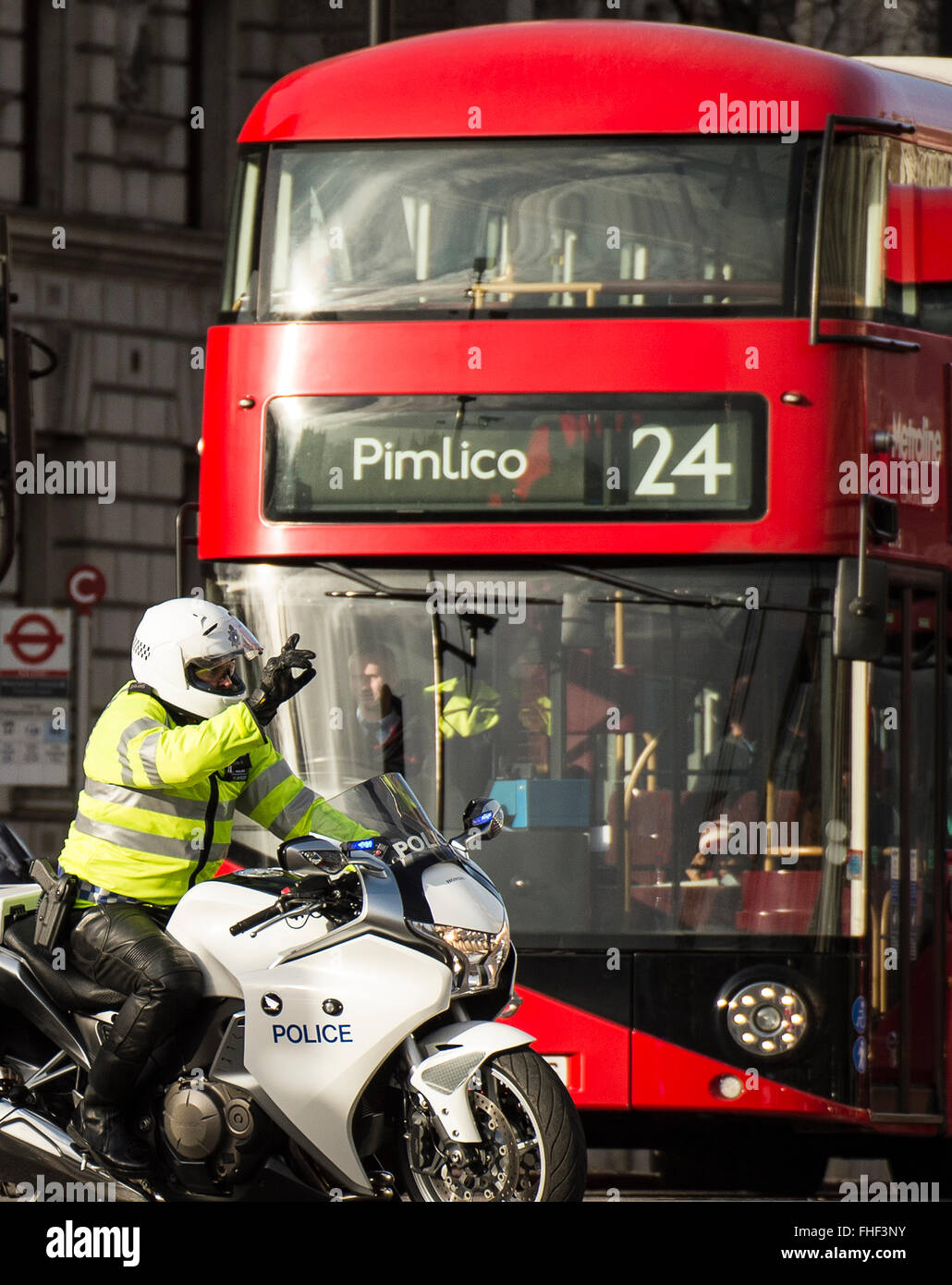 Police motorcyclist holds up traffic in Whitehall London with number 24 ...