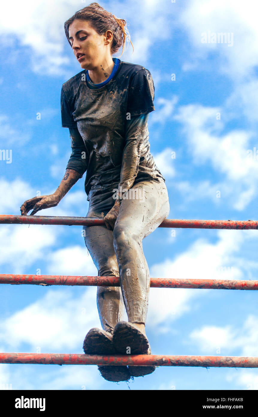 Participants in extreme obstacle race climbing over hurdle Stock Photo ...