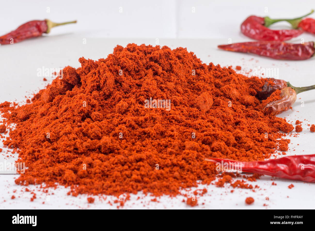 Pile of grounded red pepper and fresh peppers Stock Photo - Alamy