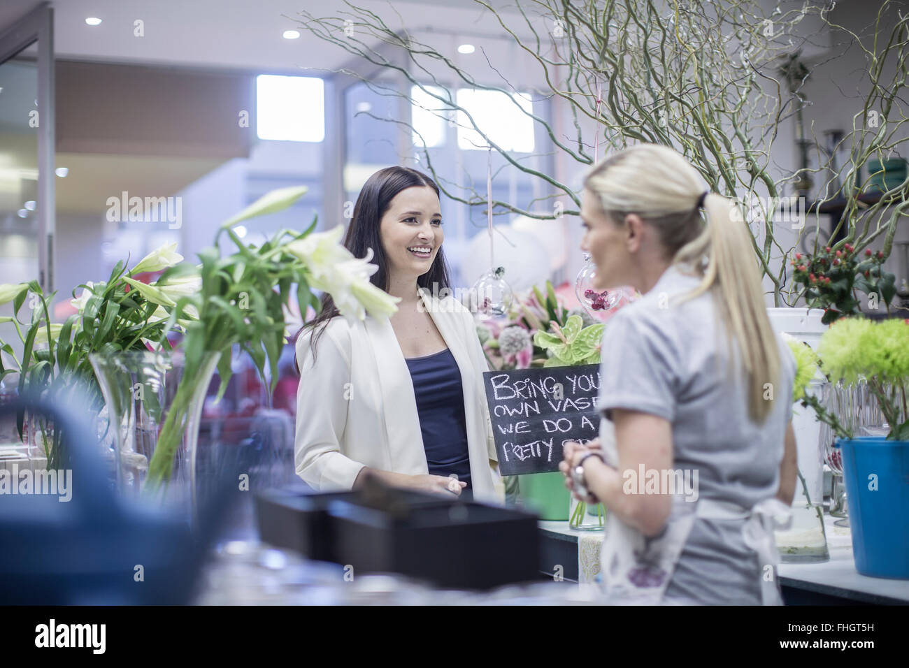 Shop assistant in flower shop talking to customer Stock Photo - Alamy