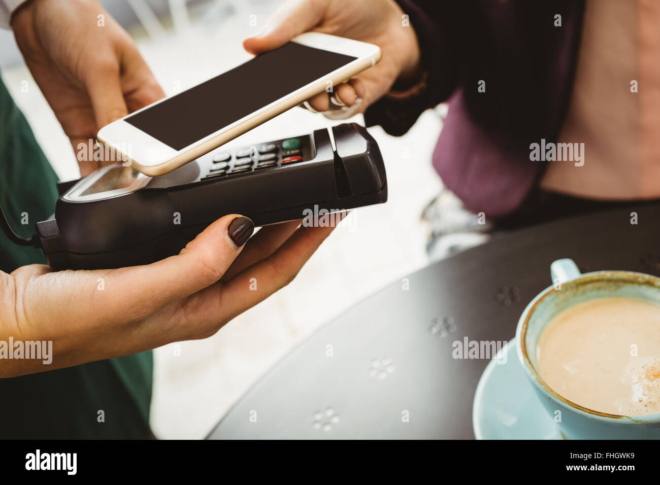 Woman paying with mobile phone Stock Photo - Alamy