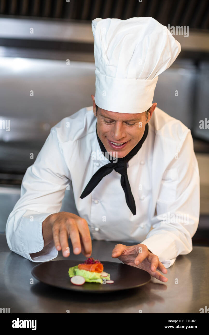 Happy chef garnishing his dish Stock Photo - Alamy