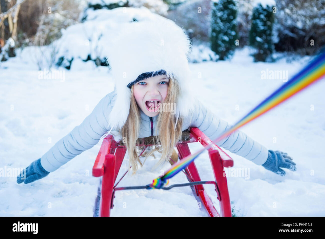 Cute girl playing with sled Stock Photo - Alamy