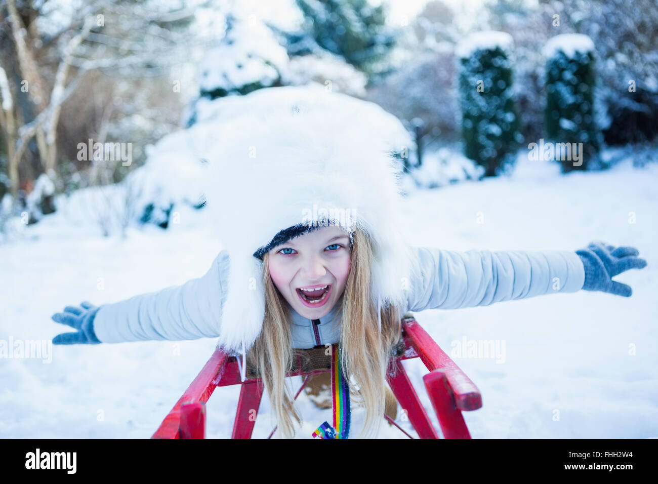 Cute girl playing with sled Stock Photo - Alamy