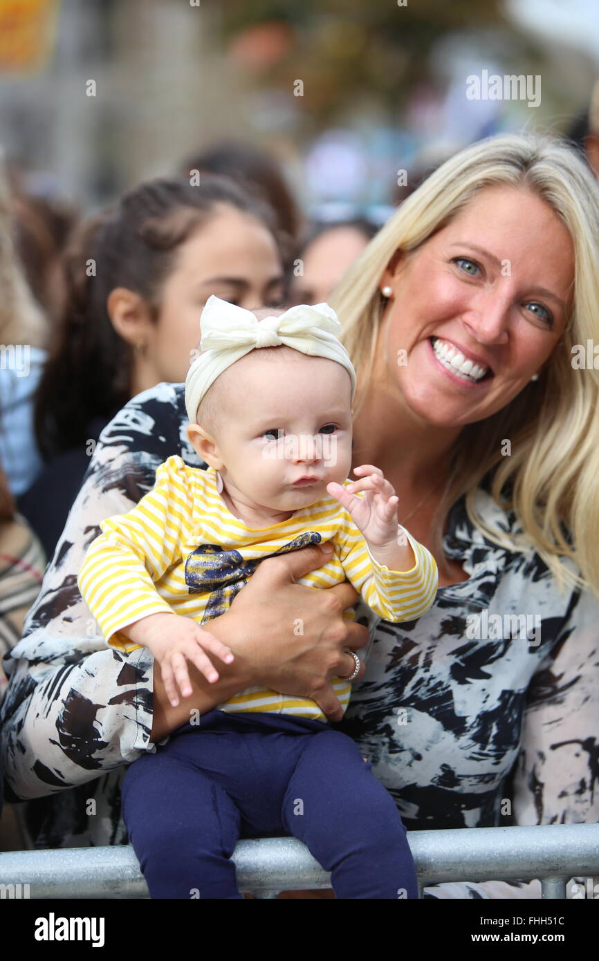 Pretty mother holds baby daughter at edge of barricade while awaiting ...