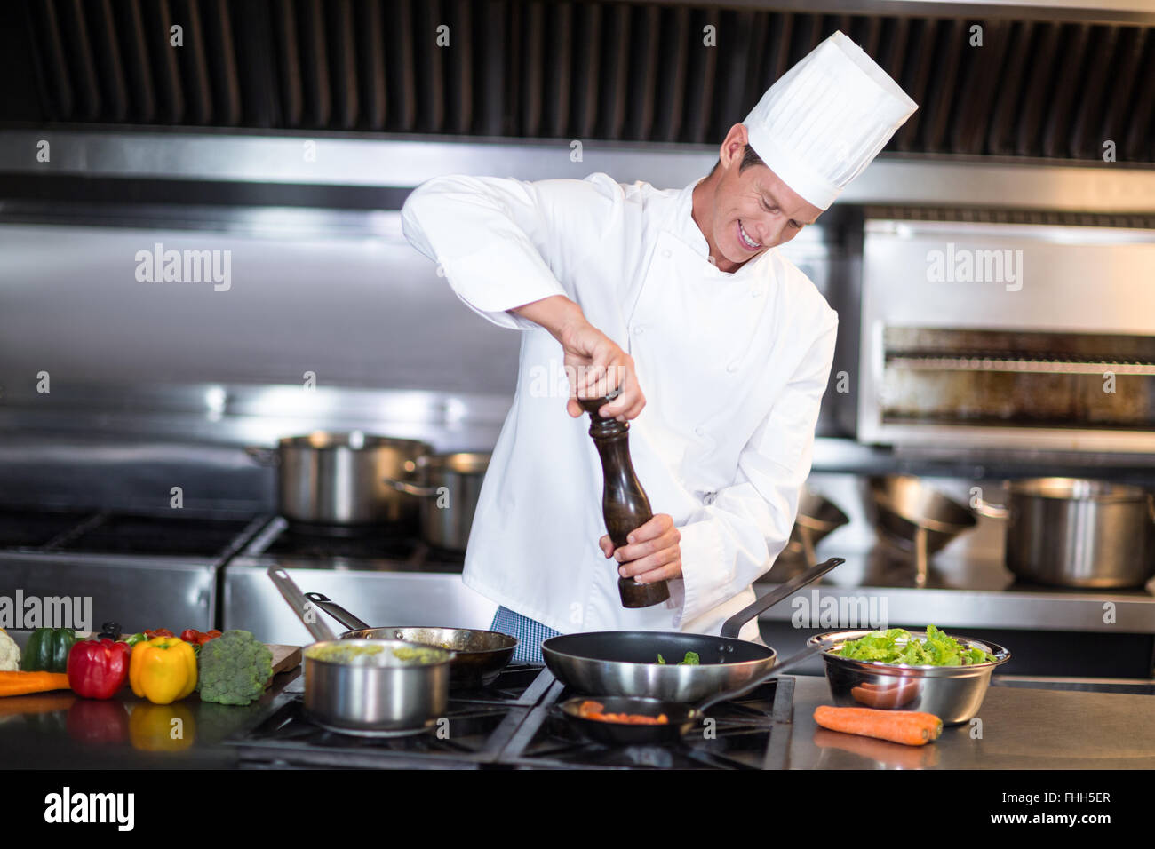 Happy chef seasoning his dish Stock Photo - Alamy