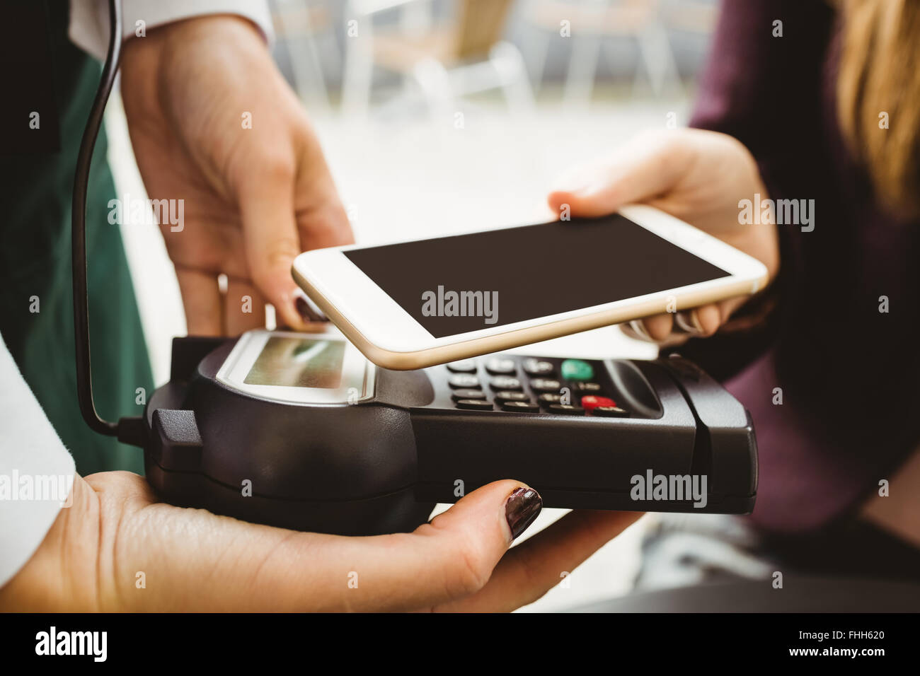 Woman paying with mobile phone Stock Photo - Alamy