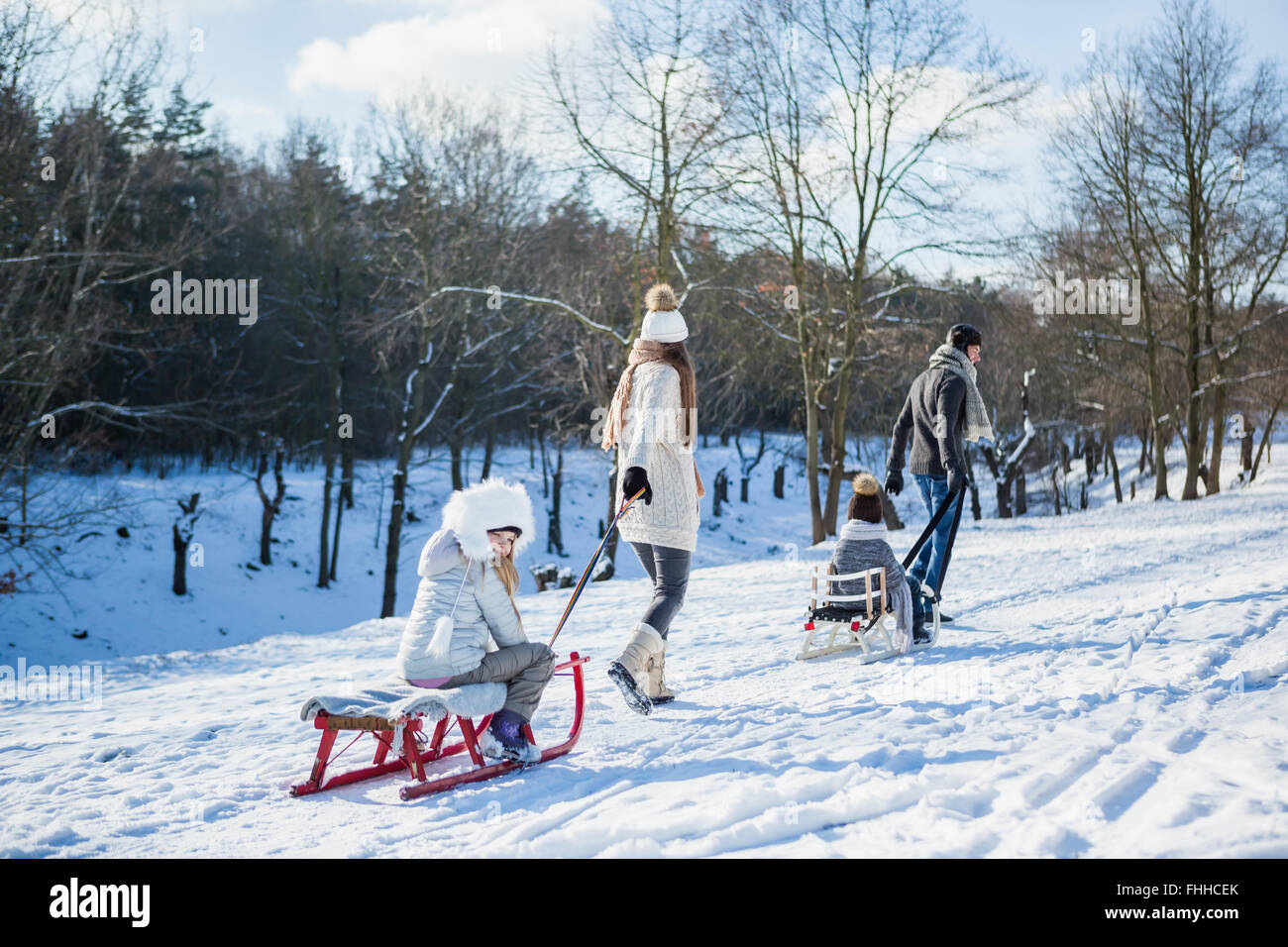 Family playing with sled Stock Photo - Alamy