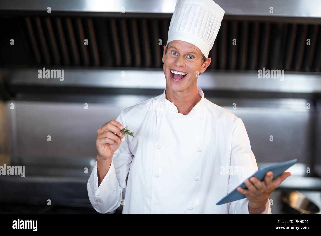 Happy chef using tablet pc while cooking Stock Photo - Alamy