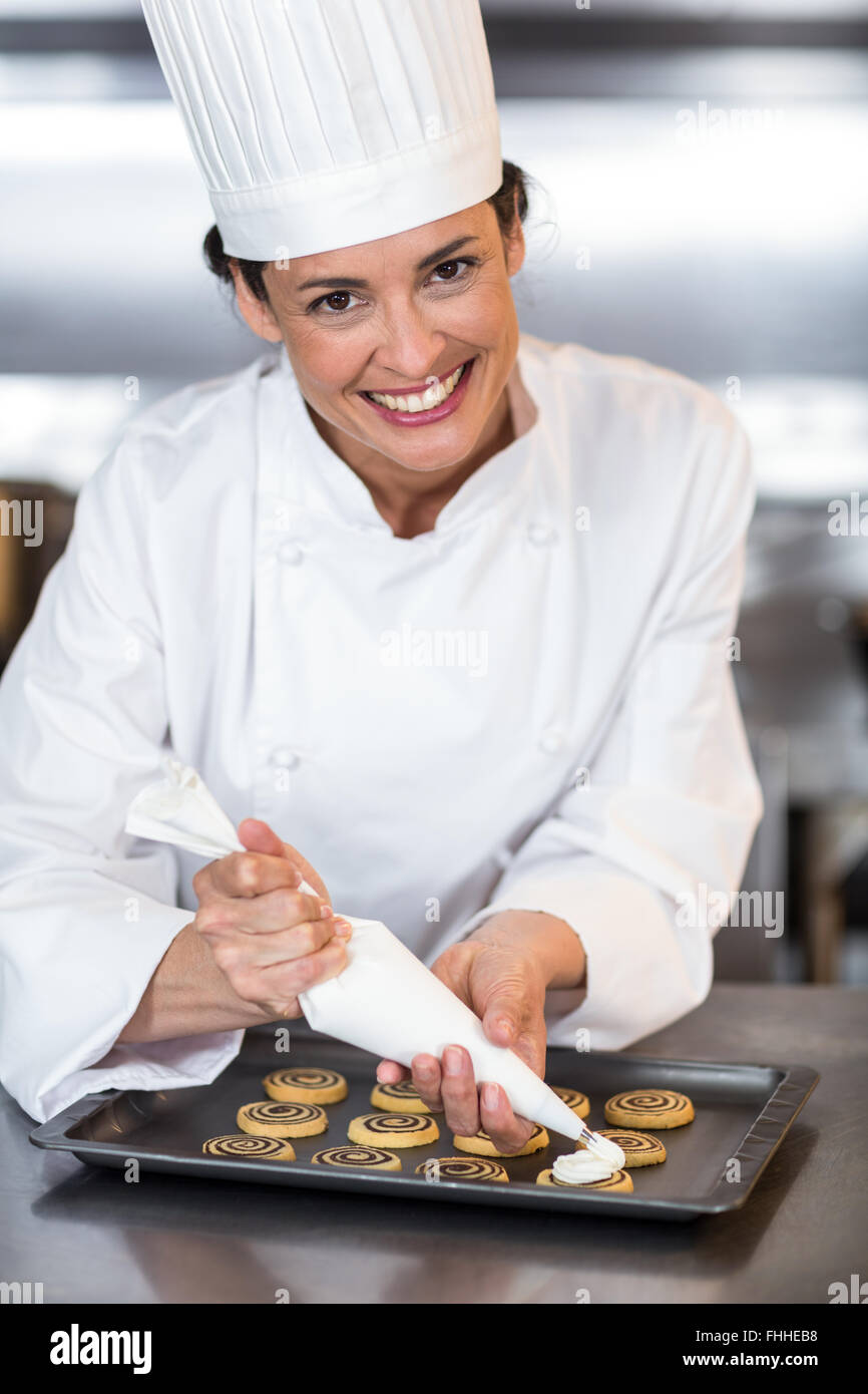 Chef piping icing on biscuits Stock Photo - Alamy