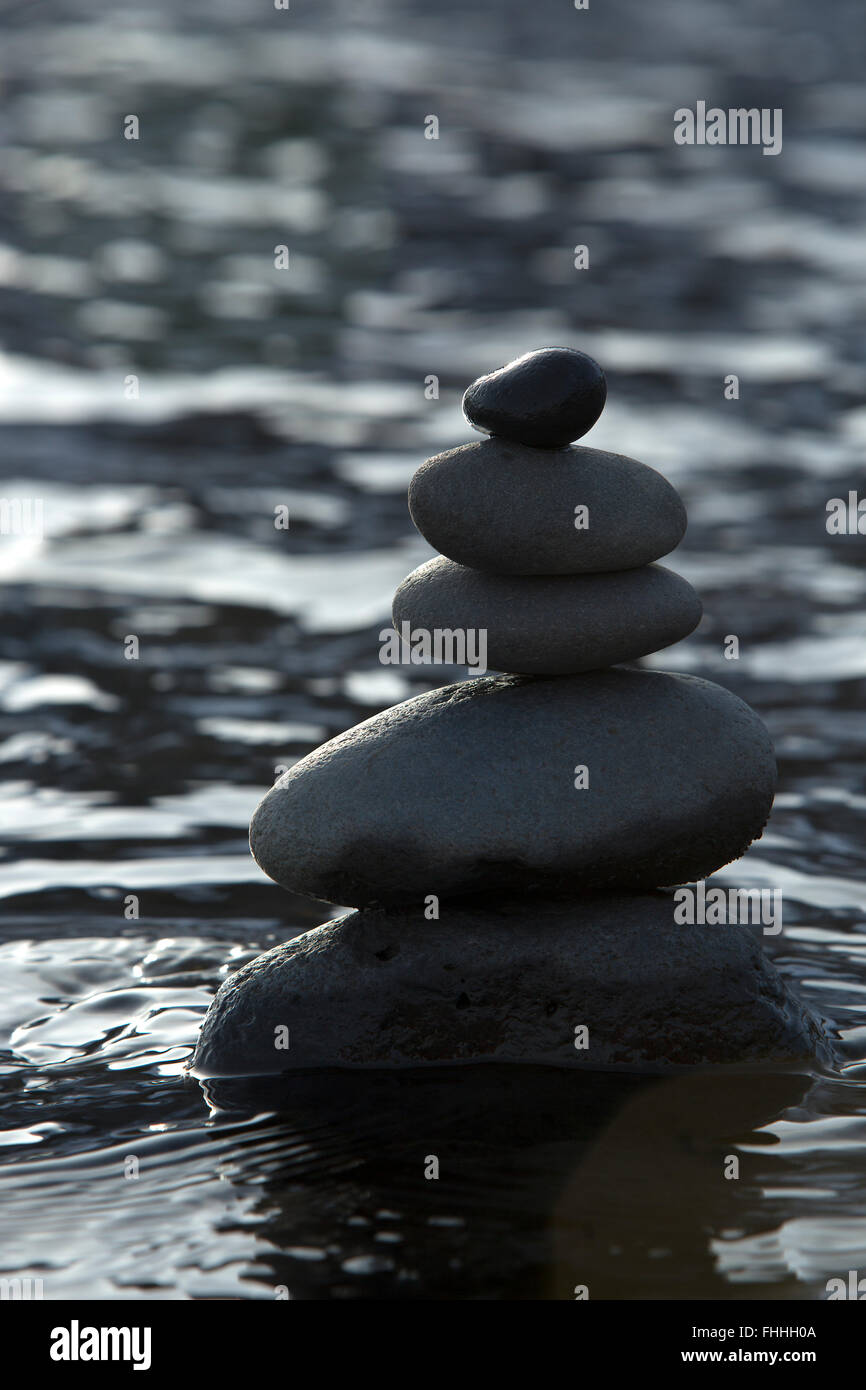 Stacked stones in water with backlit Stock Photo - Alamy
