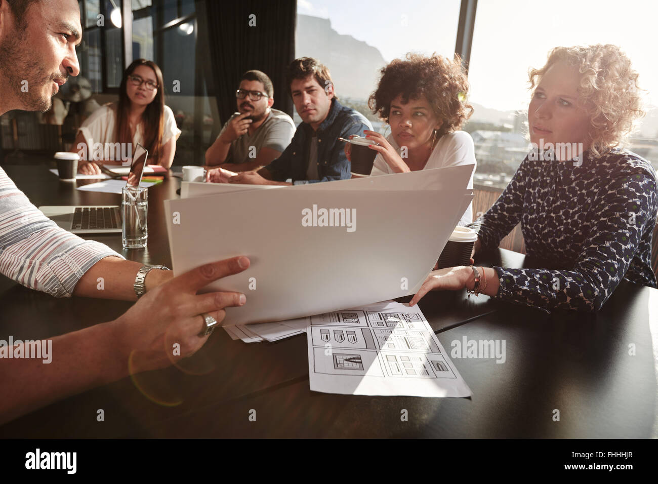 Closeup shot of team of young people going over paperwork. Creative ...
