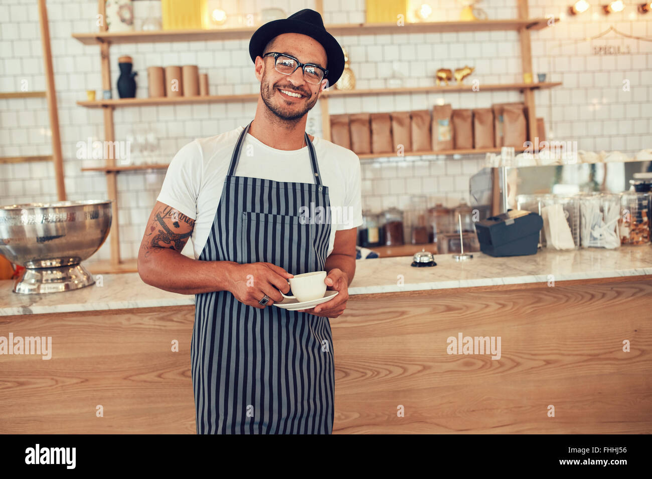 Portrait of happy young barista at work. Caucasian man wearing apron ...