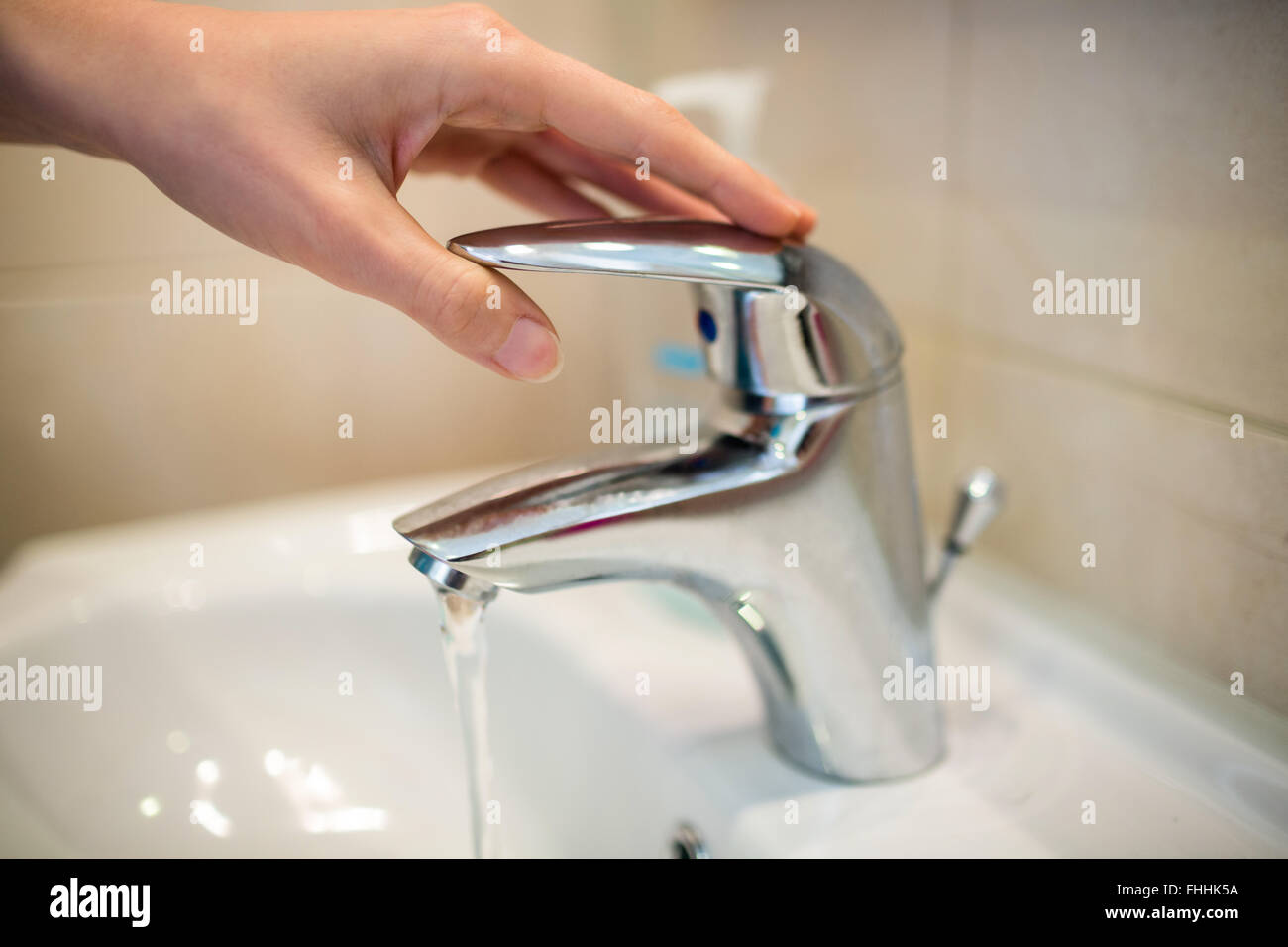 Feminine hands opening the faucet Stock Photo - Alamy