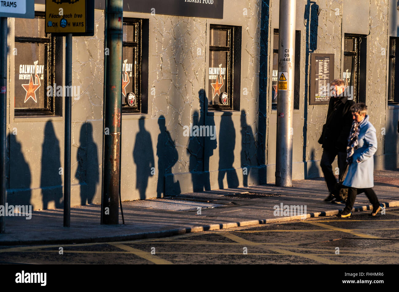 People shadows walking to work in Dublin, Ireland early winter morning ...
