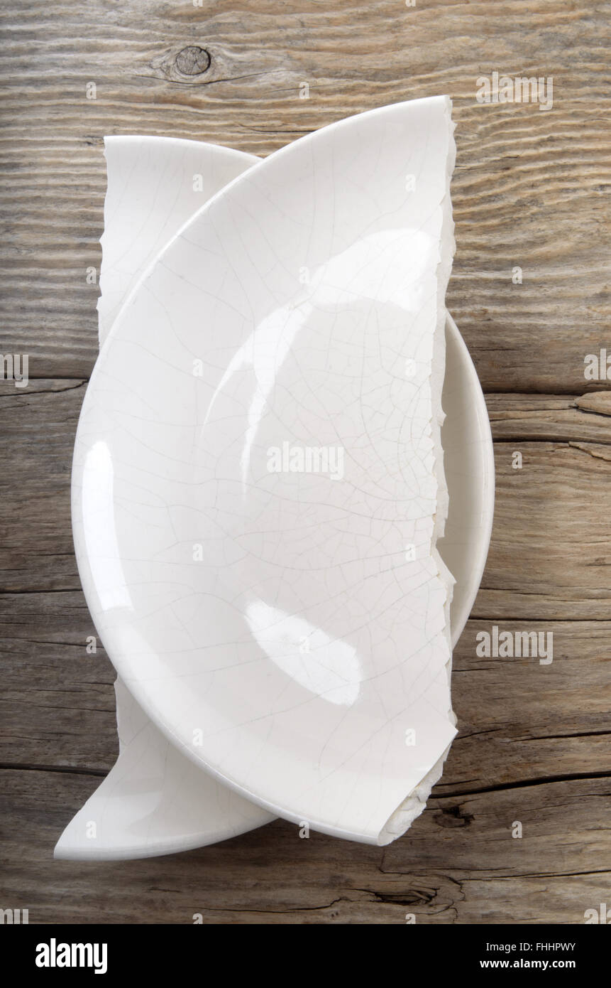 one broken white plate on an old table Stock Photo - Alamy