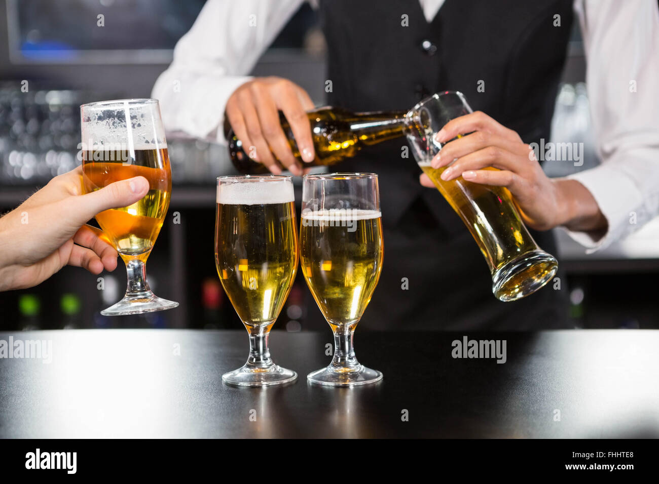Bartender serving beer at bar counter Stock Photo - Alamy