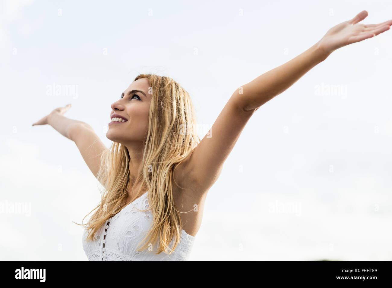 Beautiful blonde woman with arms outstretched Stock Photo - Alamy