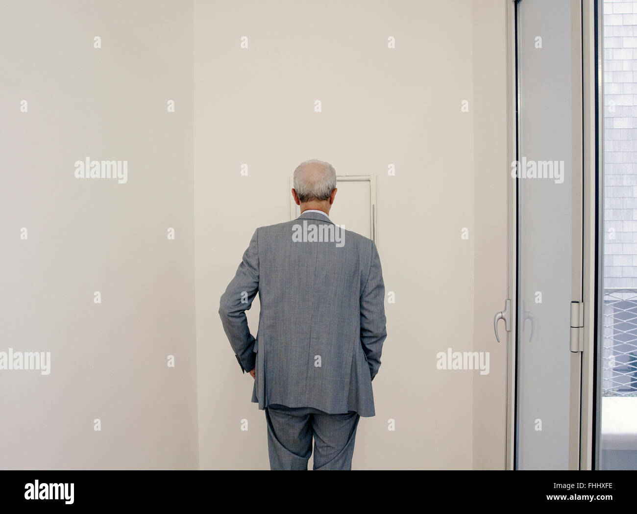 one person seen from behind watching an artwork during a gallery show ...