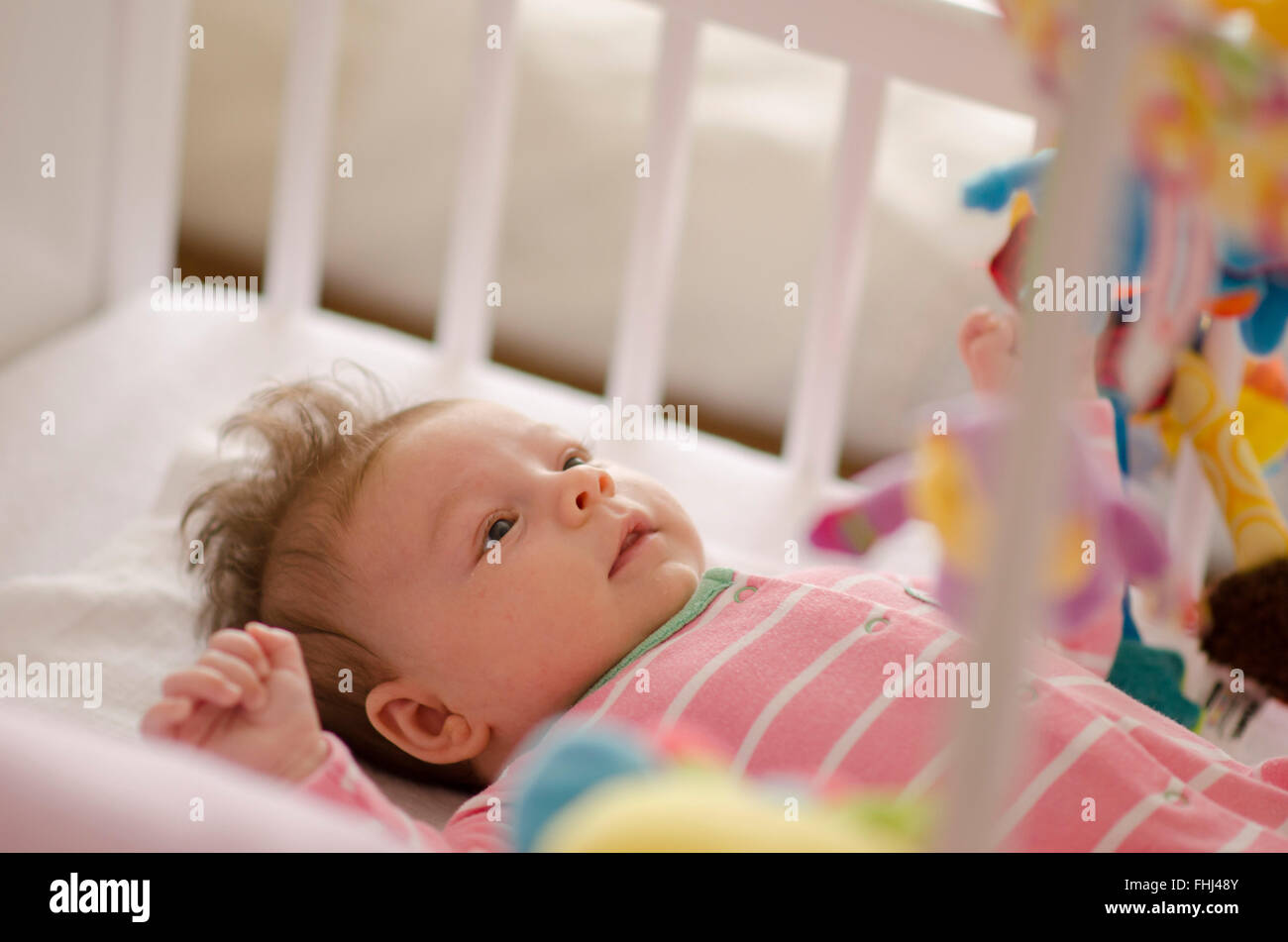 little cute baby girl playing in a cot Stock Photo - Alamy