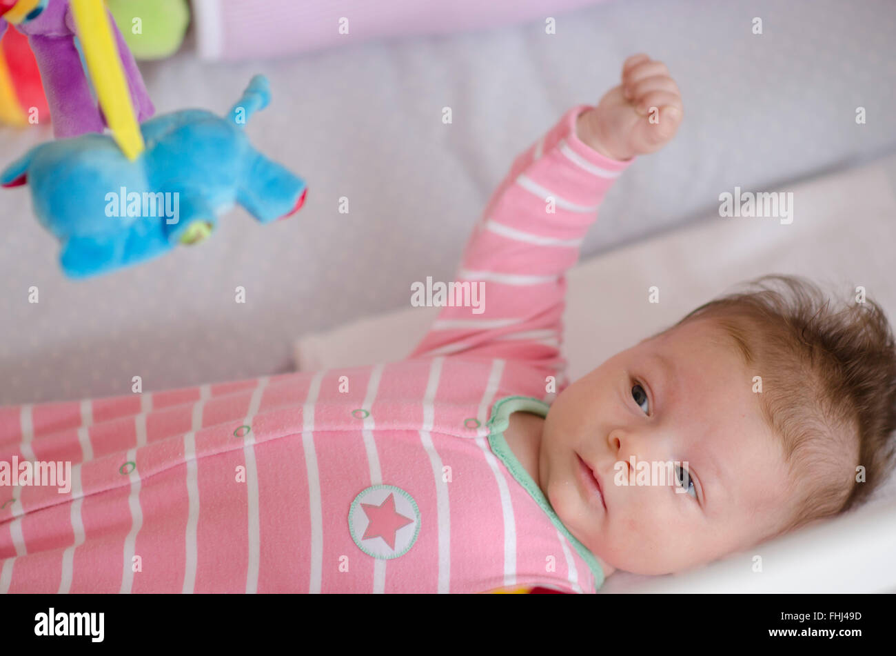 little cute baby girl playing in a cot Stock Photo - Alamy