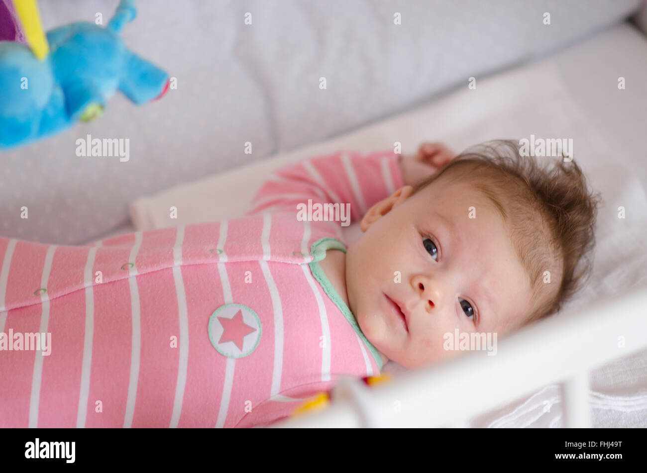 little cute baby girl playing in a cot Stock Photo - Alamy