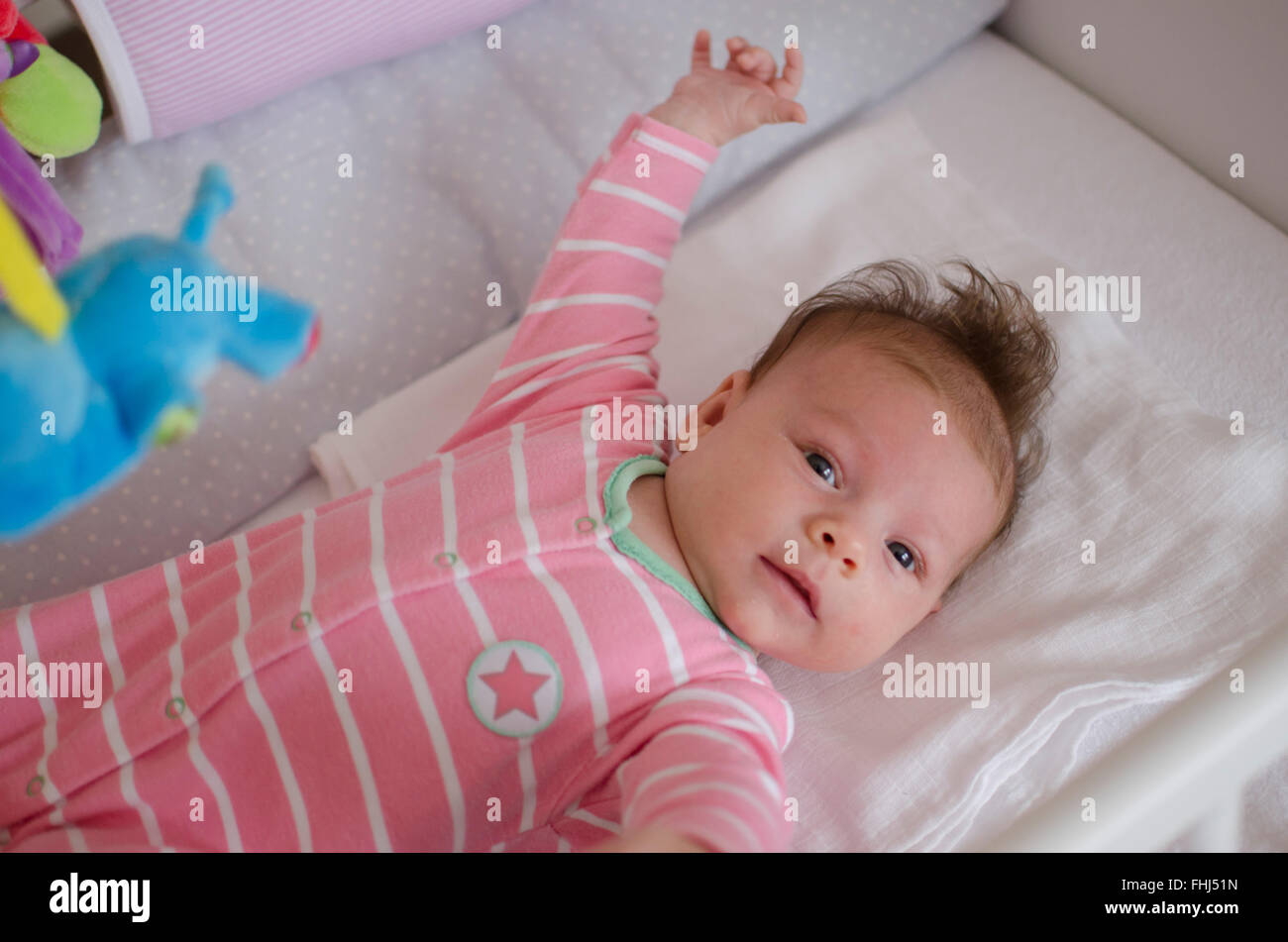 little cute baby girl playing in a cot Stock Photo - Alamy