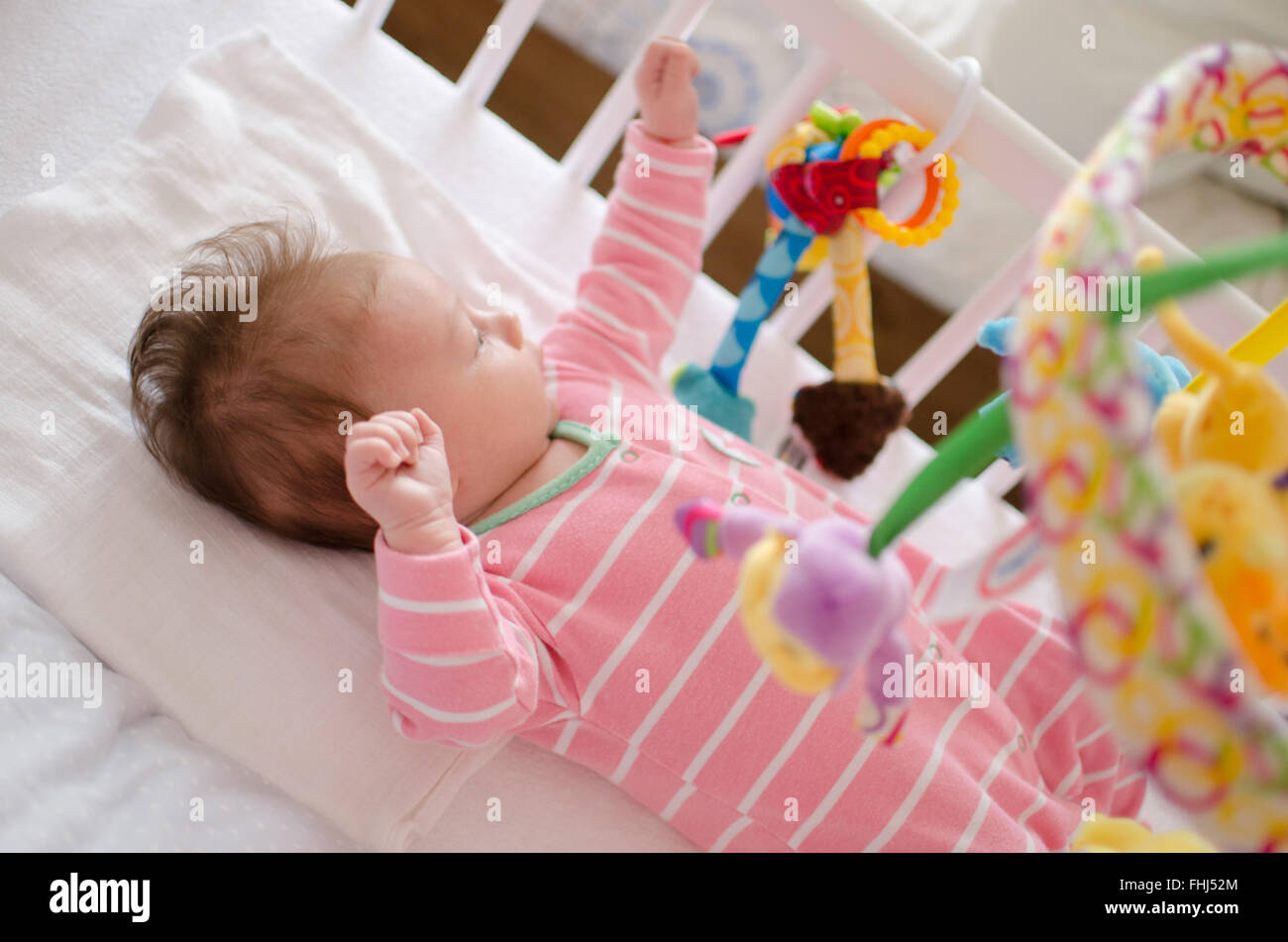 little cute baby girl playing in a cot Stock Photo - Alamy