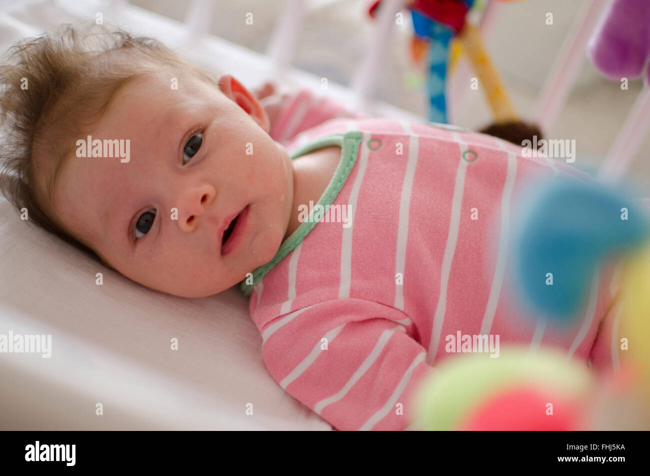 little cute baby girl playing in a cot Stock Photo - Alamy