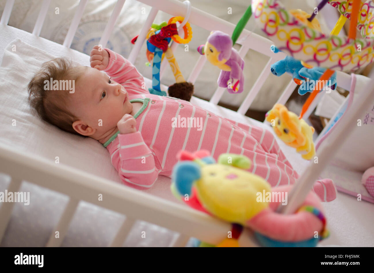 little cute baby girl playing in a cot Stock Photo - Alamy