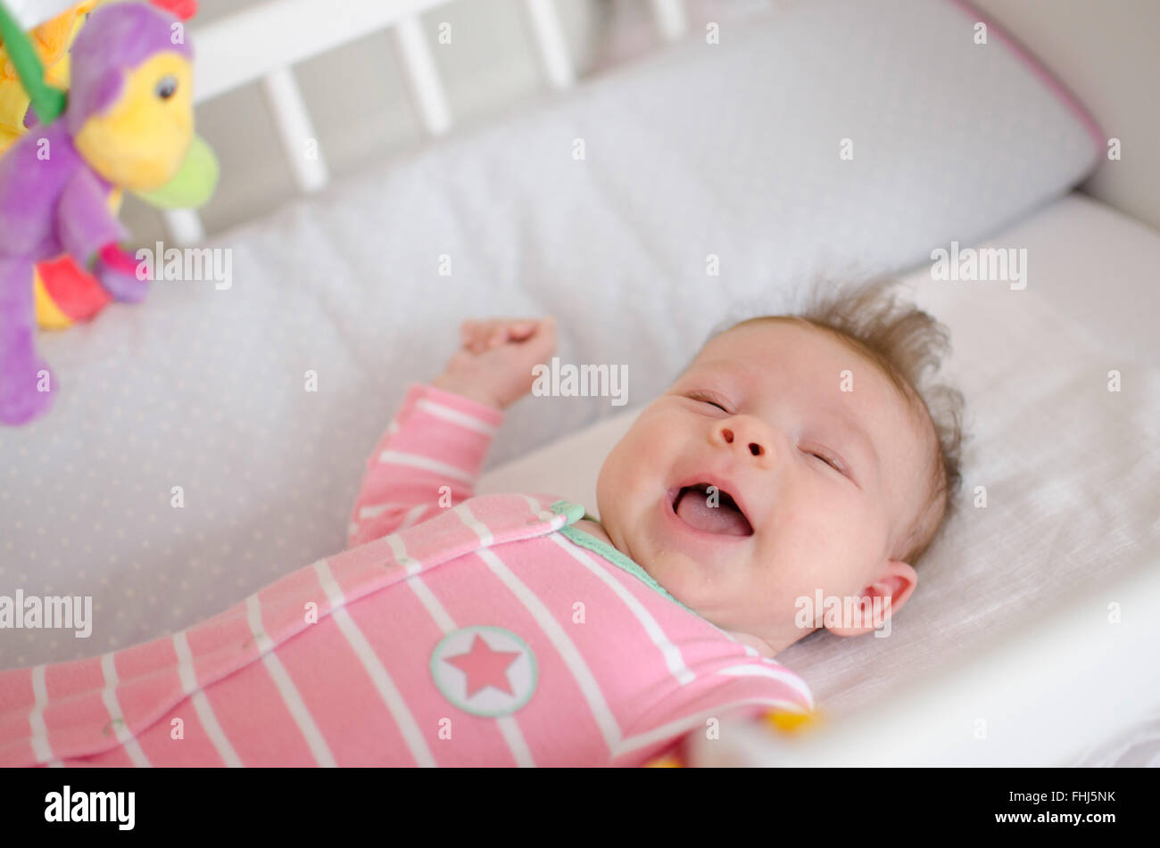 little cute baby girl playing in a cot Stock Photo - Alamy