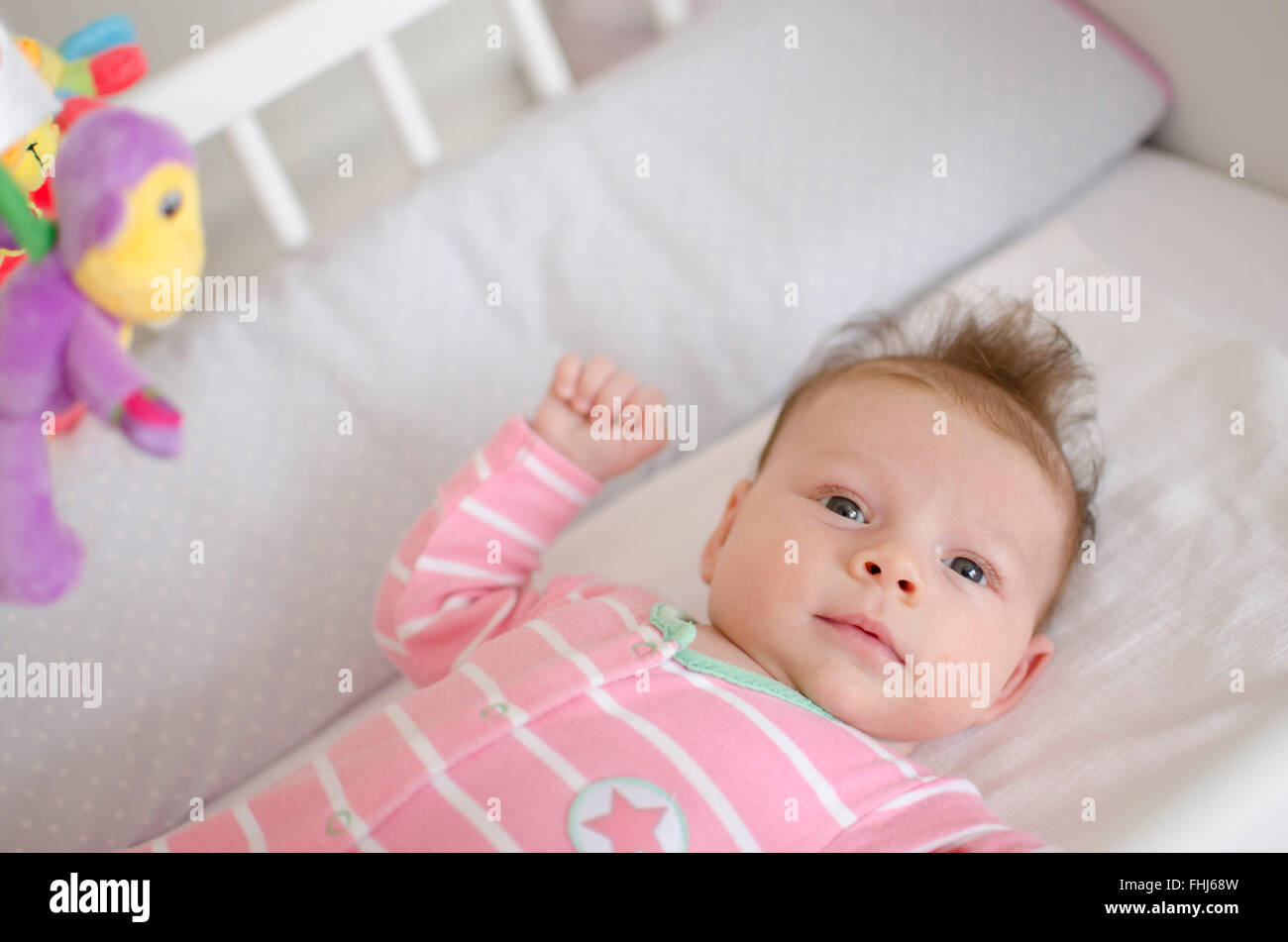 little cute baby girl playing in a cot Stock Photo - Alamy