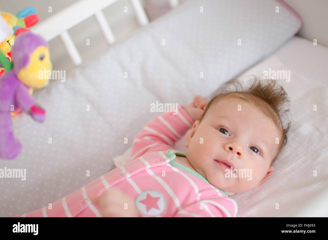 little cute baby girl playing in a cot Stock Photo - Alamy