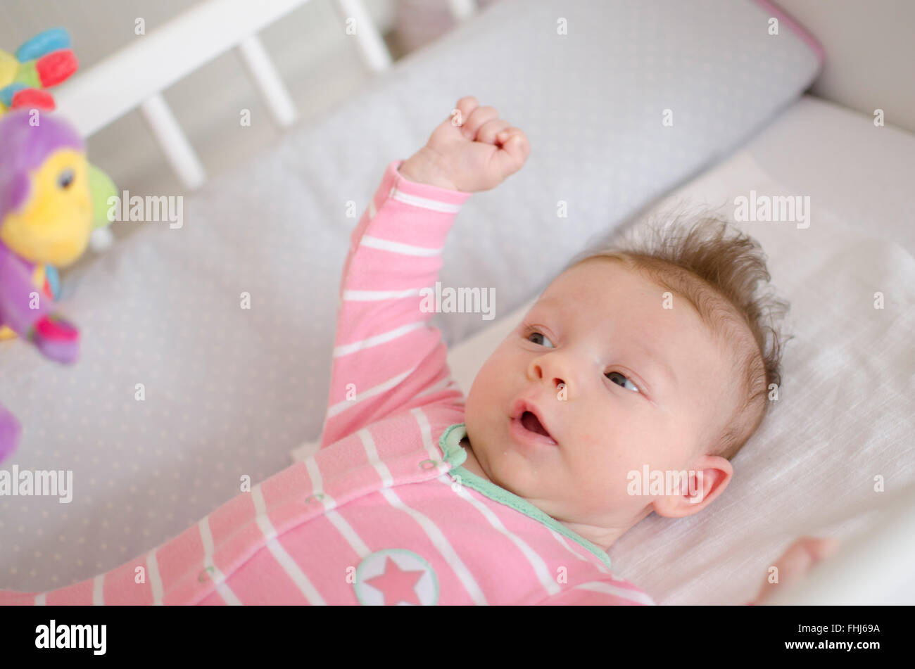 little cute baby girl playing in a cot Stock Photo - Alamy